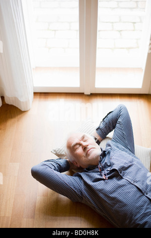 Old man resting on floor. Black and white portrait with deep shadows ...