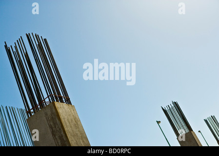 rebars or reinforcing bars from a concrete pillar with blue sky as ...