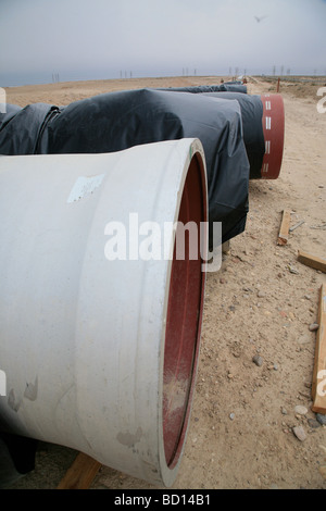 signage by industrial oil pipes ready to put in ground and connected ...