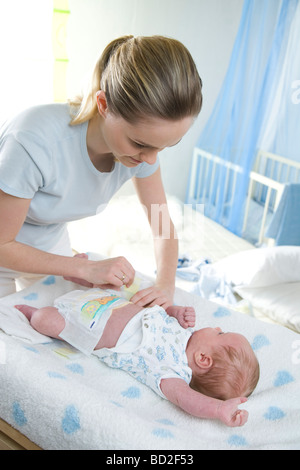 Mother put diaper for her son Stock Photo - Alamy