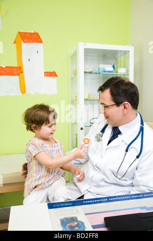 doctor giving lolly pop to toddler girl Stock Photo - Alamy