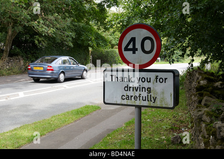 A road safety sign - Thank you for driving slowly - with a speeding car ...