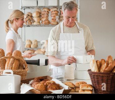 Two bakers with baskets of fresh baguettes and croissants pose in the ...