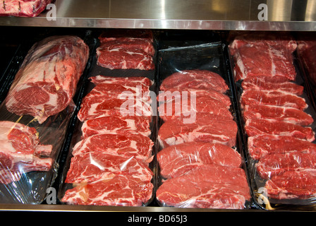 Display cooler case trays of beef steaks roasts sausages marinated ribs ...