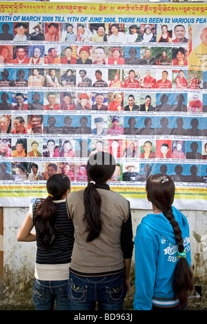 Tibetan women looking a poster showing Tibetans executed or imprisoned ...