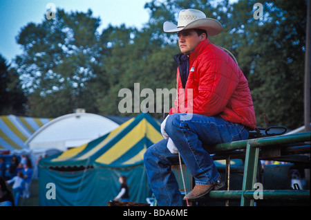 Two cowboys sit on fence overlooking rodeo arena Stock Photo - Alamy