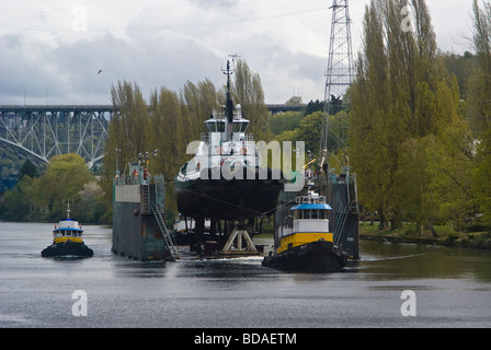 A tug being transported in a special floating dry dock from Lake Union ...