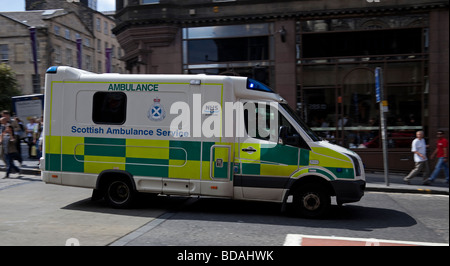 Emergency ambulance with flashing blue lights and siren working its way ...