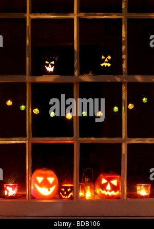 Halloween decorations with lights and carved pumpkins on window sill ...