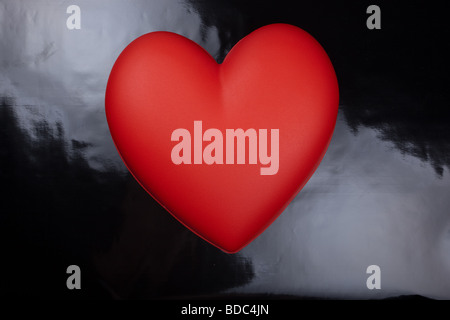 Red plastic heart lies on a white plastic background Stock Photo - Alamy
