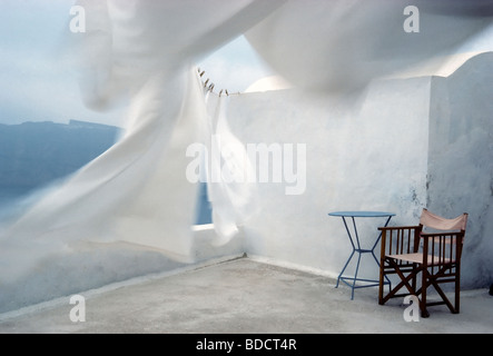 White roof-deck of a Cycladic house, white laundry hung out to dry ...