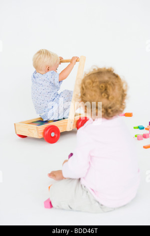 Cute baby with push toy learning to walk on white background Stock ...