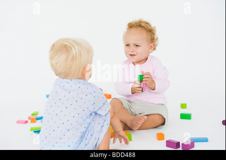 Two boys playing with toy blocks in a room Stock Photo - Alamy
