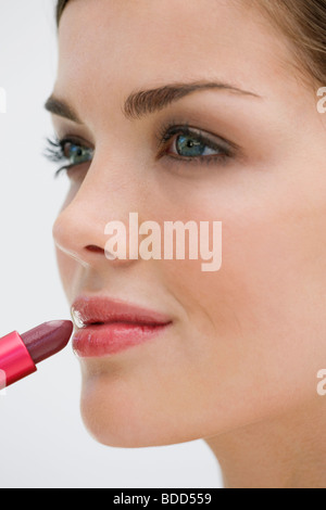 Fashion model applying lipstick on her lips Stock Photo - Alamy