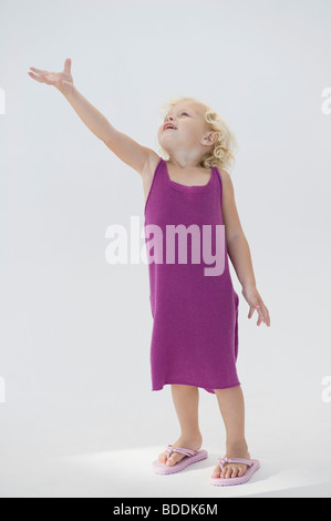 Girl standing with hand raised Stock Photo - Alamy