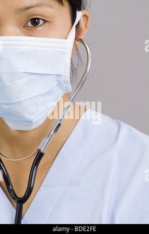 Young Asian woman doctor in white medical coat speaking on mobile phone ...