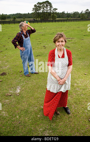 Worried man in red apron looking at fresh limes citrus fruits yellow ...