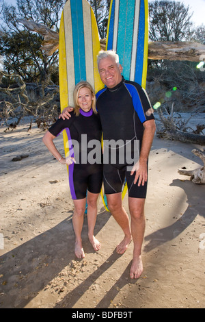 Middle-aged surfer couple on beach with surfboard Stock Photo - Alamy