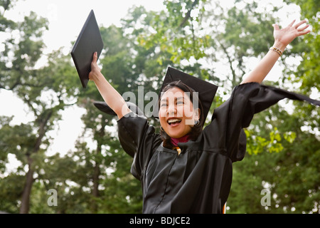 East Asian excited graduates cheering and jumping in campus Stock Photo ...