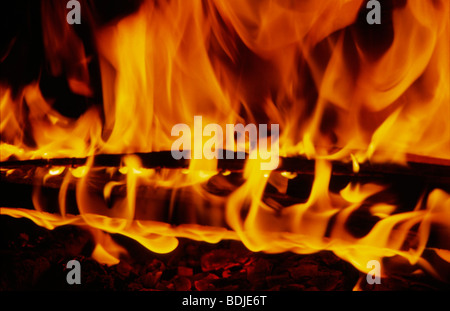 A closeup shot of a burning wood logs bonfire, stacked crosswise on top ...