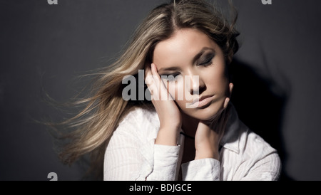 Young attractive woman with light shadows across face making startled ...