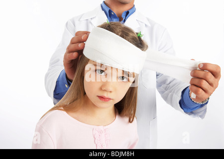 Doctor Wrapping Bandage Around Girl's Head Stock Photo - Alamy