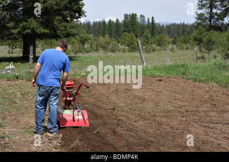 Man rototilling the ground, getting it ready for a garden Stock Photo ...