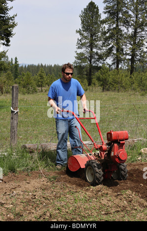 Man rototilling the ground, getting it ready for a garden Stock Photo ...