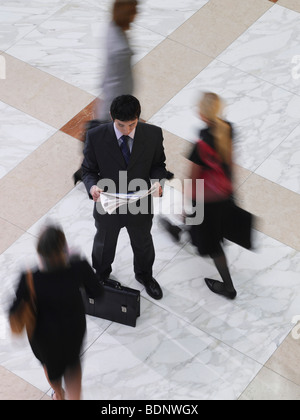 Business man reading very long paper roll in office Stock Photo - Alamy