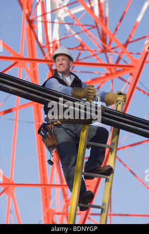 Cable lineman climbing a ladder to repair transmission line Stock Photo ...
