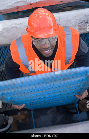Industrial engineer climbing ladder with safety cage at a power plant ...