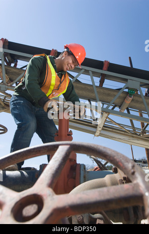 Asian worker at construction machinery of construction site or mining ...