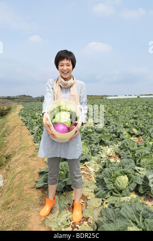 Smiling woman standing on field during winter Stock Photo - Alamy