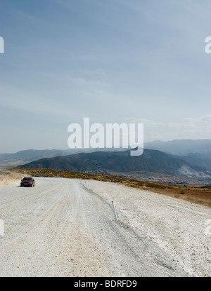 empty gravel dust road in forest with sun rays and shadows. early ...