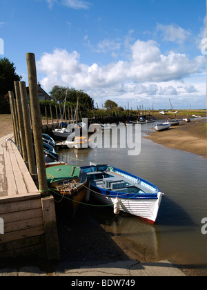 A small pleasure craft boat moored to a rickety wooden jetty on the ...