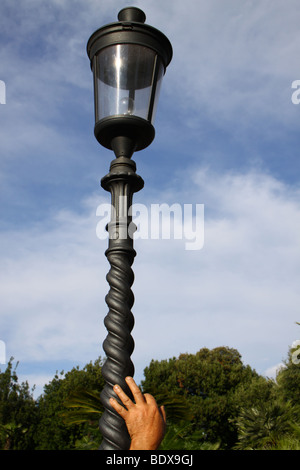 A man's hand leaning on a spiral lamp post Stock Photo - Alamy