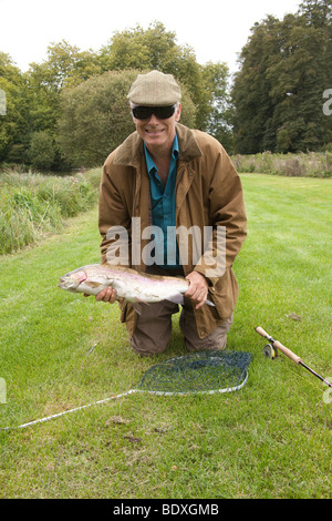 Trout fly fisherman with a large 6lb rainbow trout, Avington Fishery ...