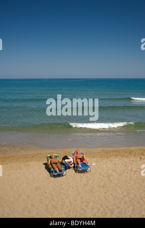 Crete beach holiday Woman sunbathing on beach at Malia on the Greek ...