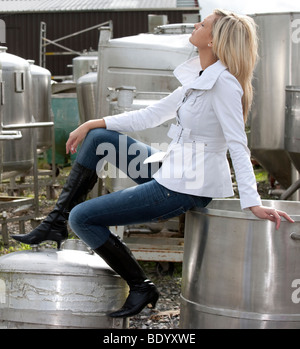 Blond woman sitting on scrap metal stainless steel Stock Photo - Alamy