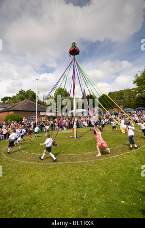 School children perform a Maypole dance routine dressed in traditional ...
