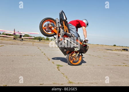 Stunt bike rider making stoppie Stock Photo - Alamy