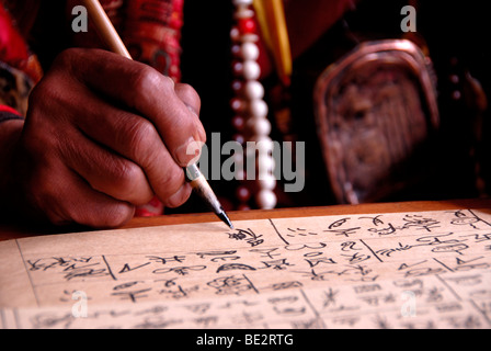 Priest writing ancient Dongba script, hands, Dongba Research Center at ...