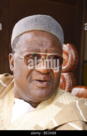 Sultan Ibrahim Mbombo Njoya in front of the Sultan's palace, holding an ...