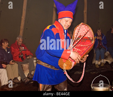 Middle aged Sami man in traditional clothing demonstrates techniques ...