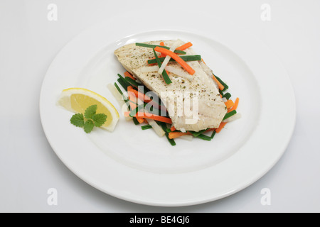 Steamed Saithe fillet on a bed of colourful vegetables Stock Photo - Alamy