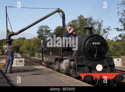 A steam engine refilling water in station Stock Photo - Alamy