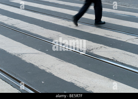 Person walking over a zebra crossing in the city center Stock Photo - Alamy