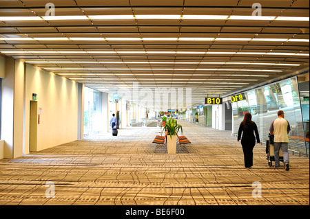 Passengers walking through passenger boarding bridge in airport ...
