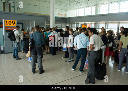 AIRPORT GATE QUEUE Airline passengers waiting at check-in to board ...