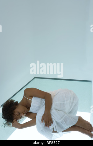 Woman curled up in fetal position on grass Stock Photo - Alamy